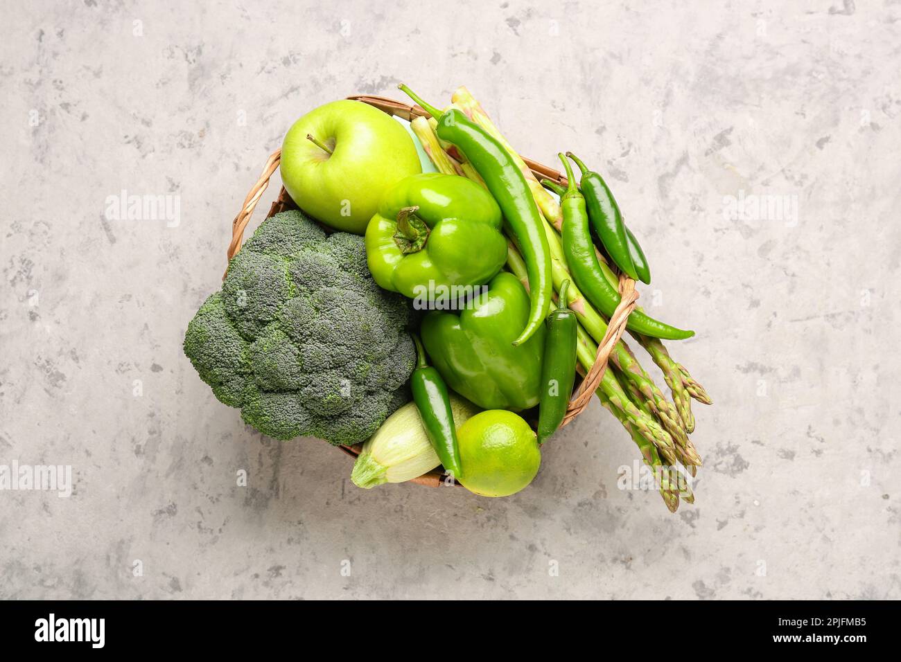 Basket with different fresh vegetables and fruits on grunge background ...
