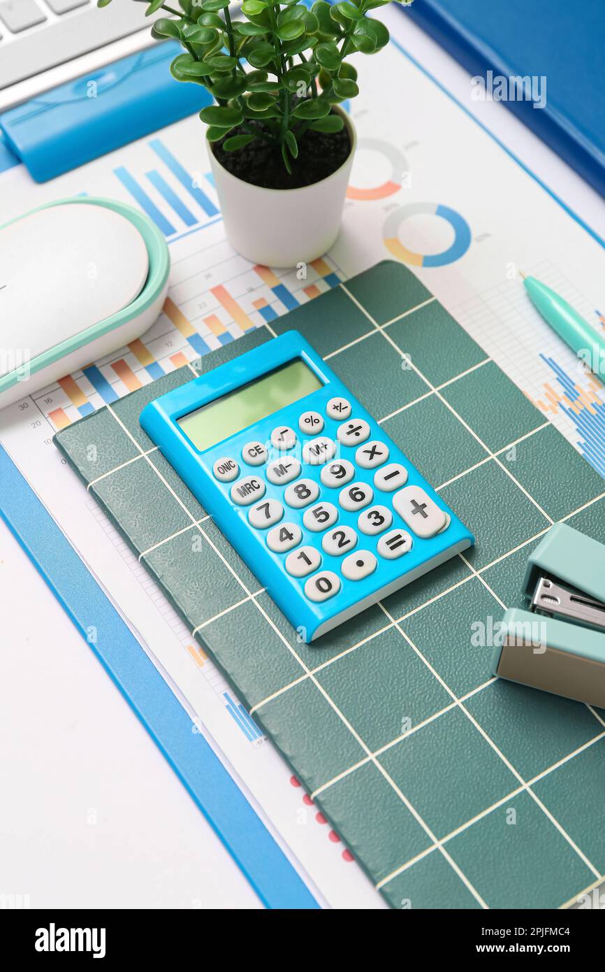 Composition with notepad, calculator, documents and plant on light ...