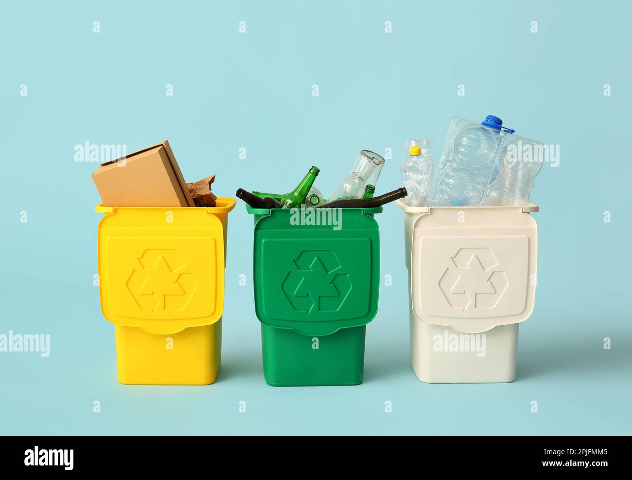 Containers with different types of garbage on light blue background ...