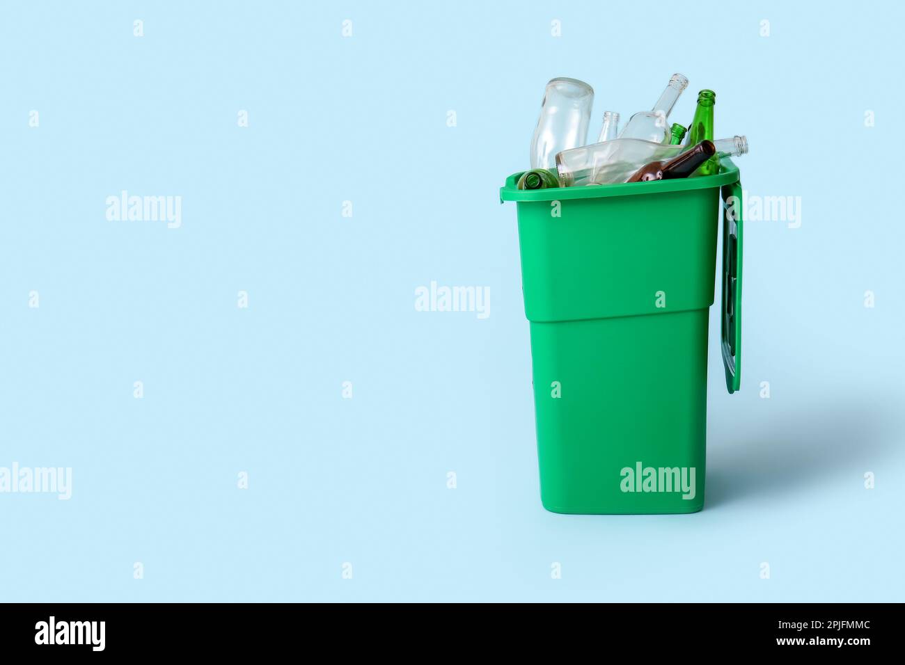 Container for garbage with glass bottles on light blue background ...