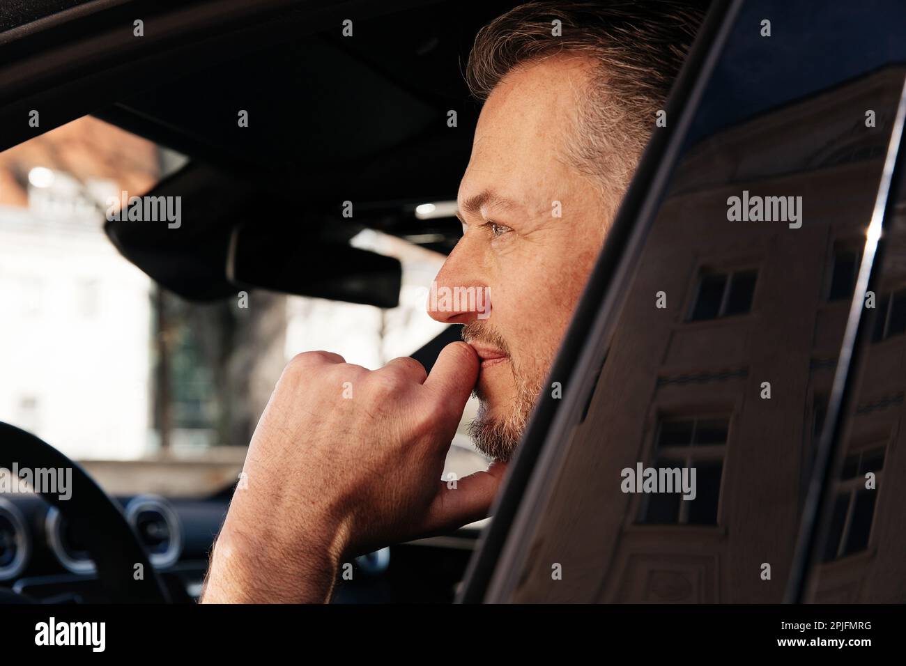 Attractive businessman in a casual cloth driving a car in the city ...