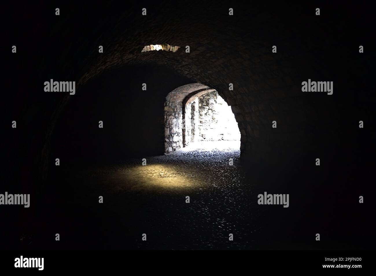 Dark and covered passage in the boundary wall of a castle Stock Photo ...