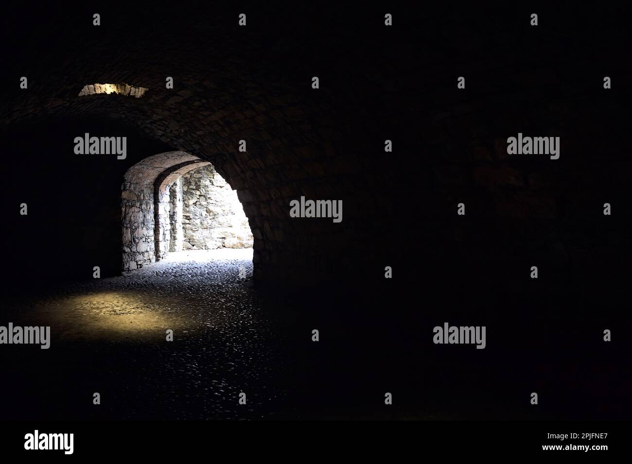 Dark and covered passage in the boundary wall of a castle Stock Photo ...