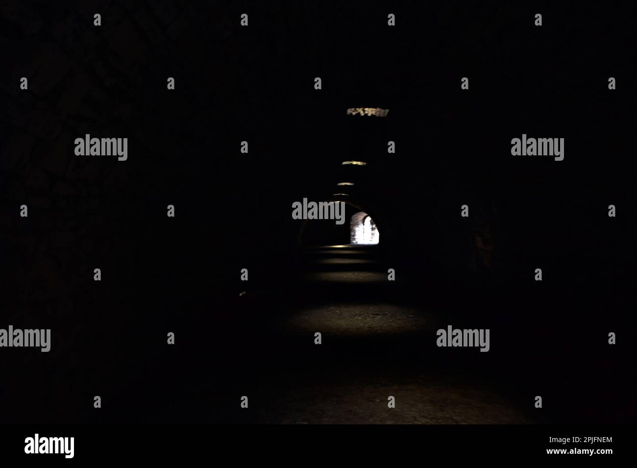 Dark and covered passage in the boundary wall of a castle Stock Photo ...