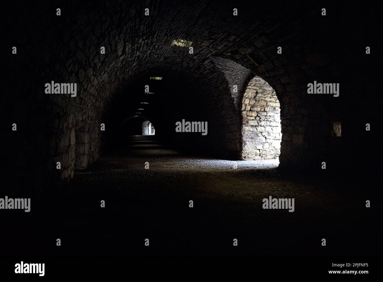 Dark and covered passage in the boundary wall of a castle Stock Photo ...