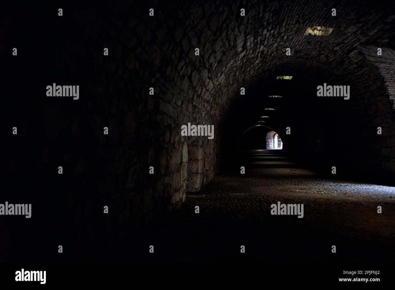 Dark and covered passage in the boundary wall of a castle Stock Photo ...