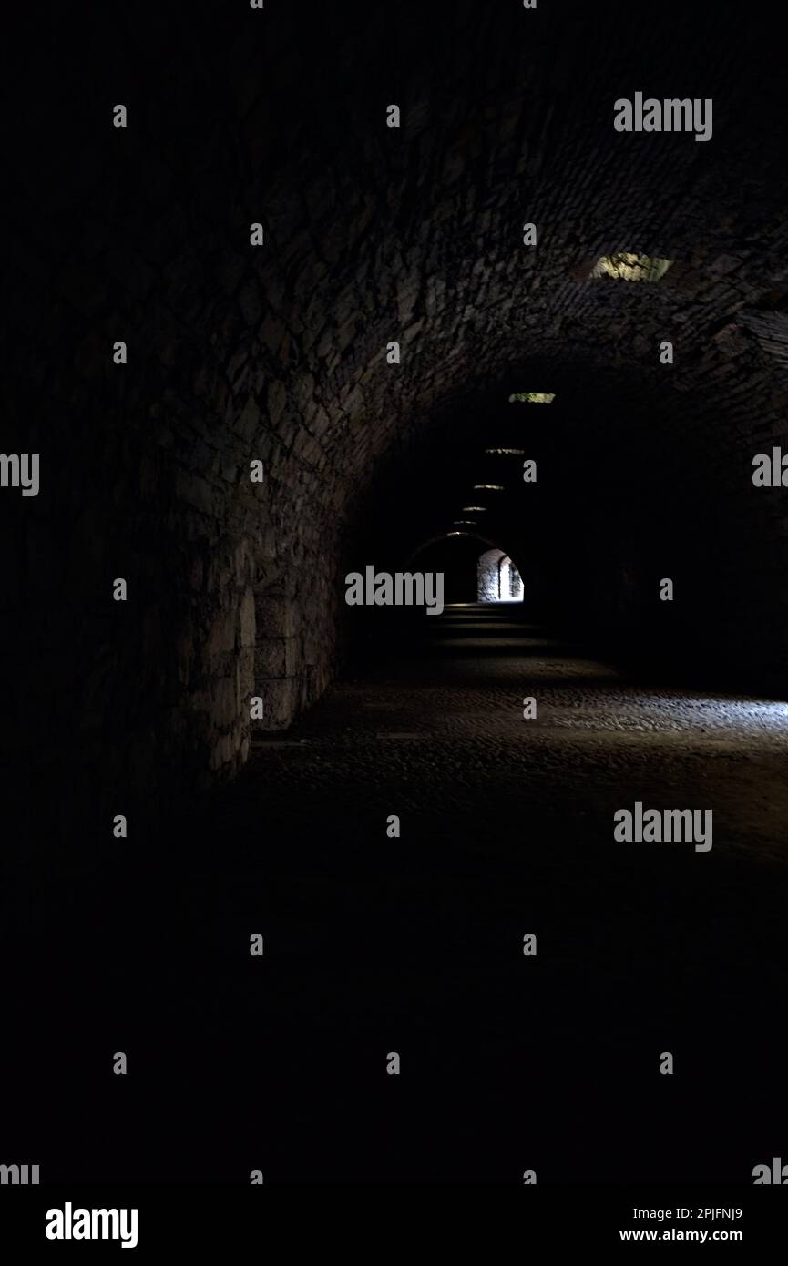 Dark and covered passage in the boundary wall of a castle Stock Photo ...