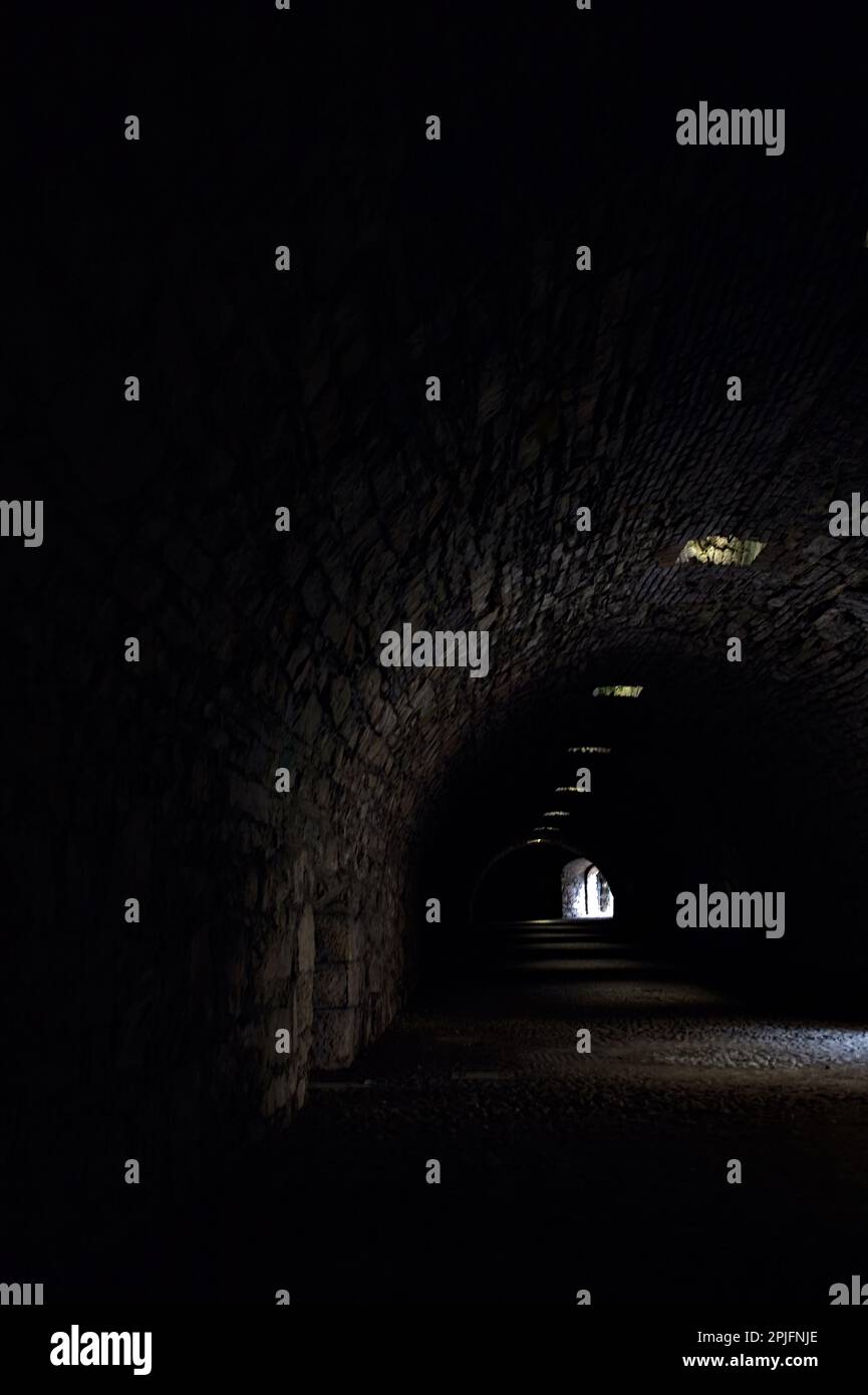 Dark and covered passage in the boundary wall of a castle Stock Photo ...