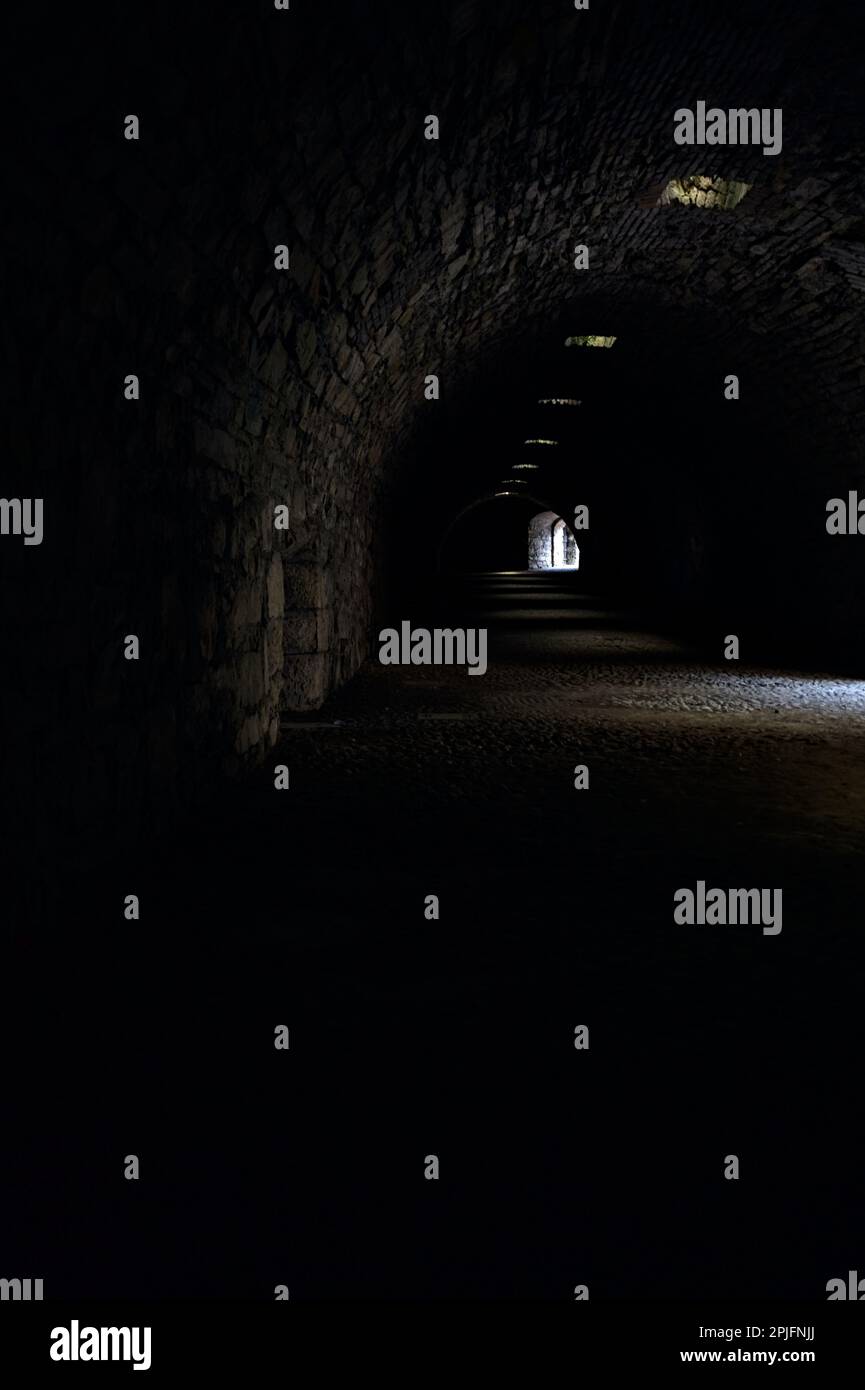 Dark and covered passage in the boundary wall of a castle Stock Photo ...