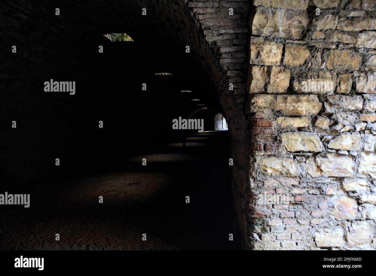 Dark and covered passage in the boundary wall of a castle Stock Photo ...