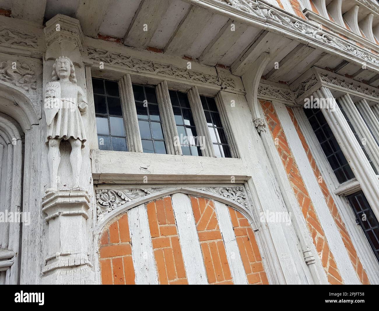 Detail from the front of a medieval hall showing windows and a carved ...