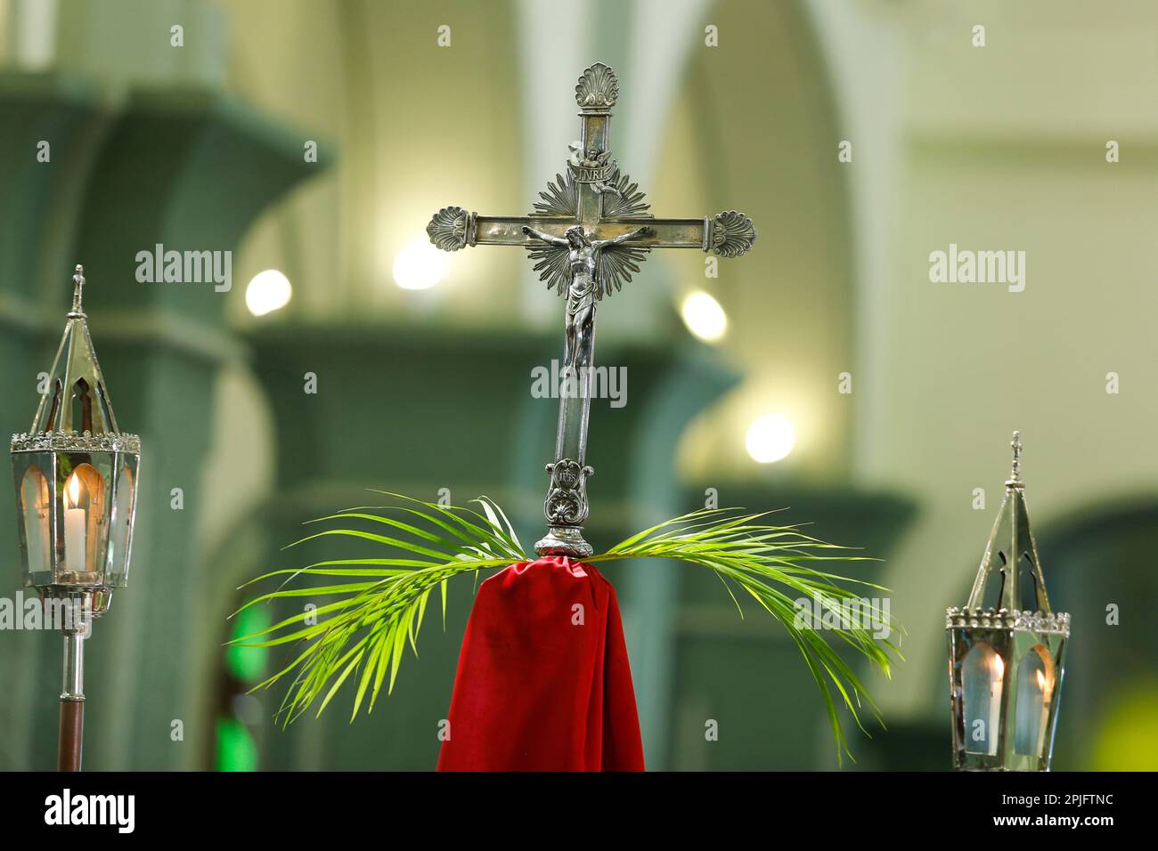 Holy Week. Metal cross with green branches. Traditional Catholic celebration Palm Sunday ...