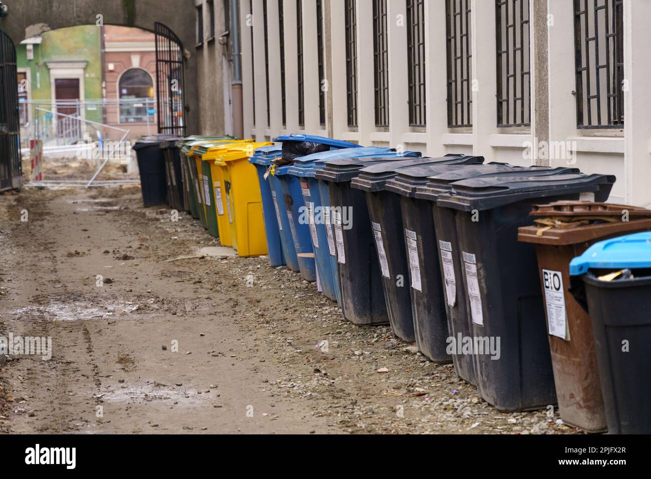Rows of garbage cans of different colors in an alley in the city center ...