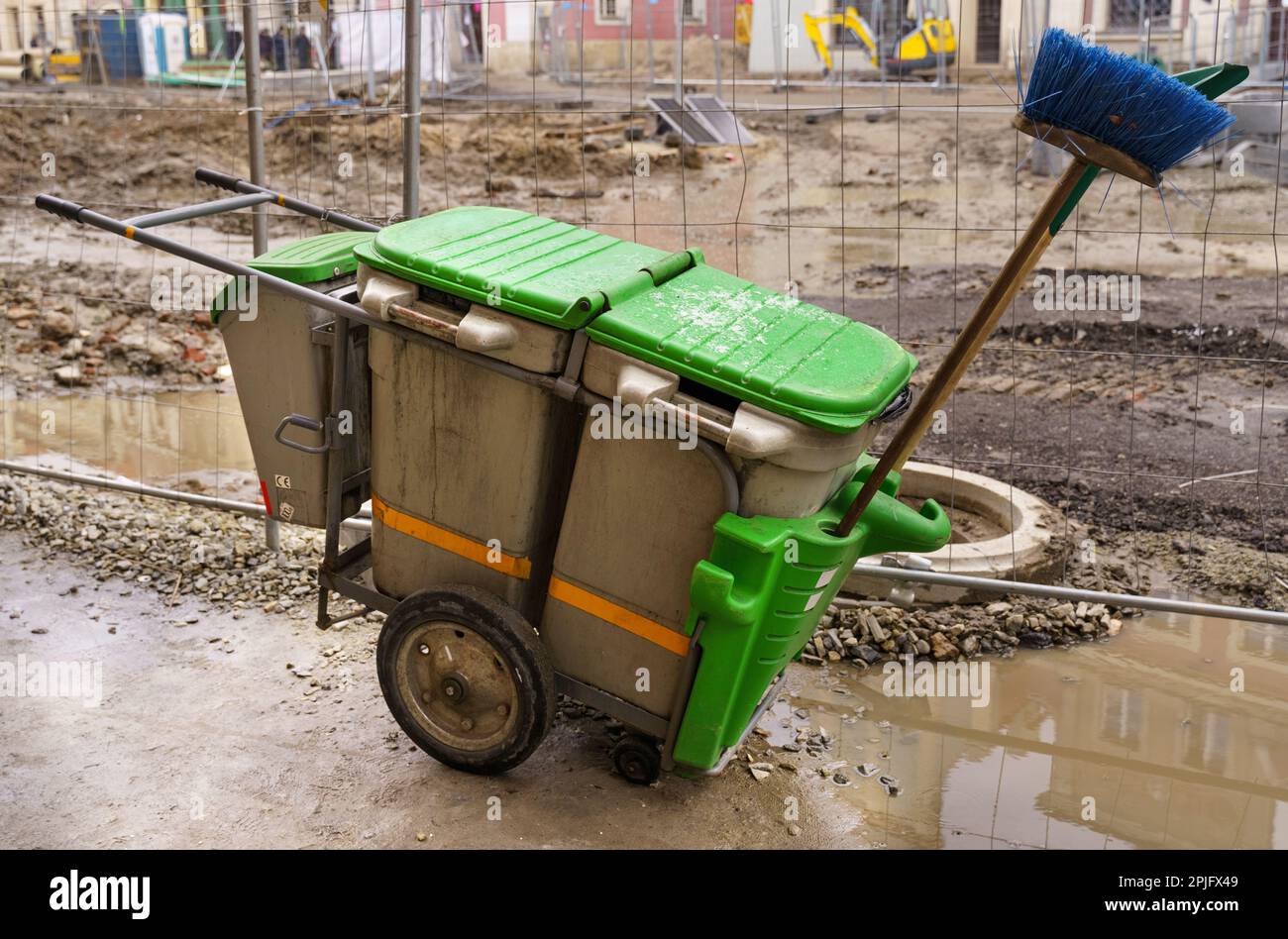 Green trolley container for street cleaning, stands near the ...