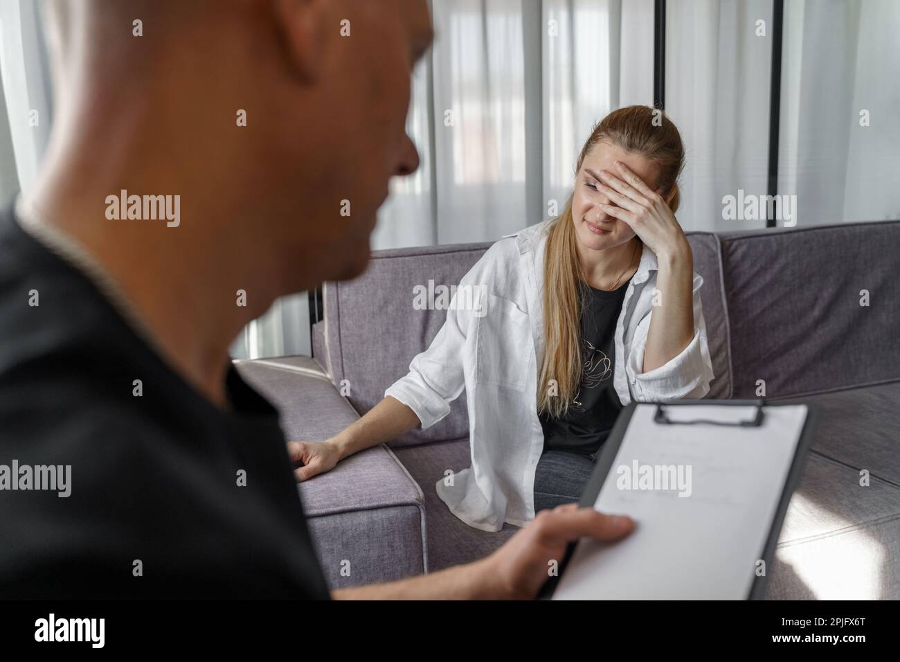 A male psychologist consults a female patient, makes notes. A woman ...
