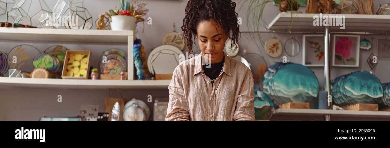 Woman is packing handmade candles for selling in own home decor studio ...