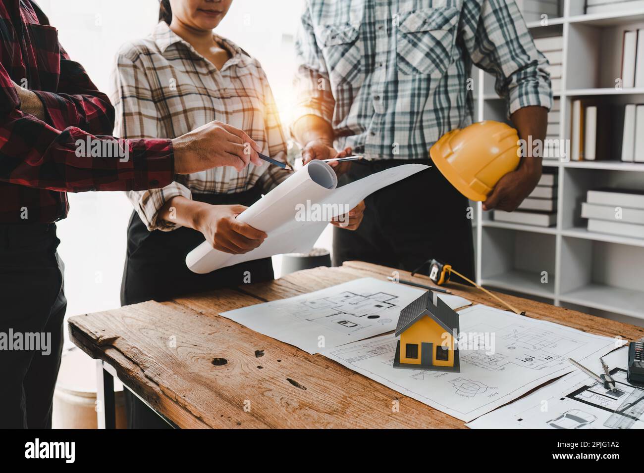 Architect and Engineer working with blueprints for architectural plan ...