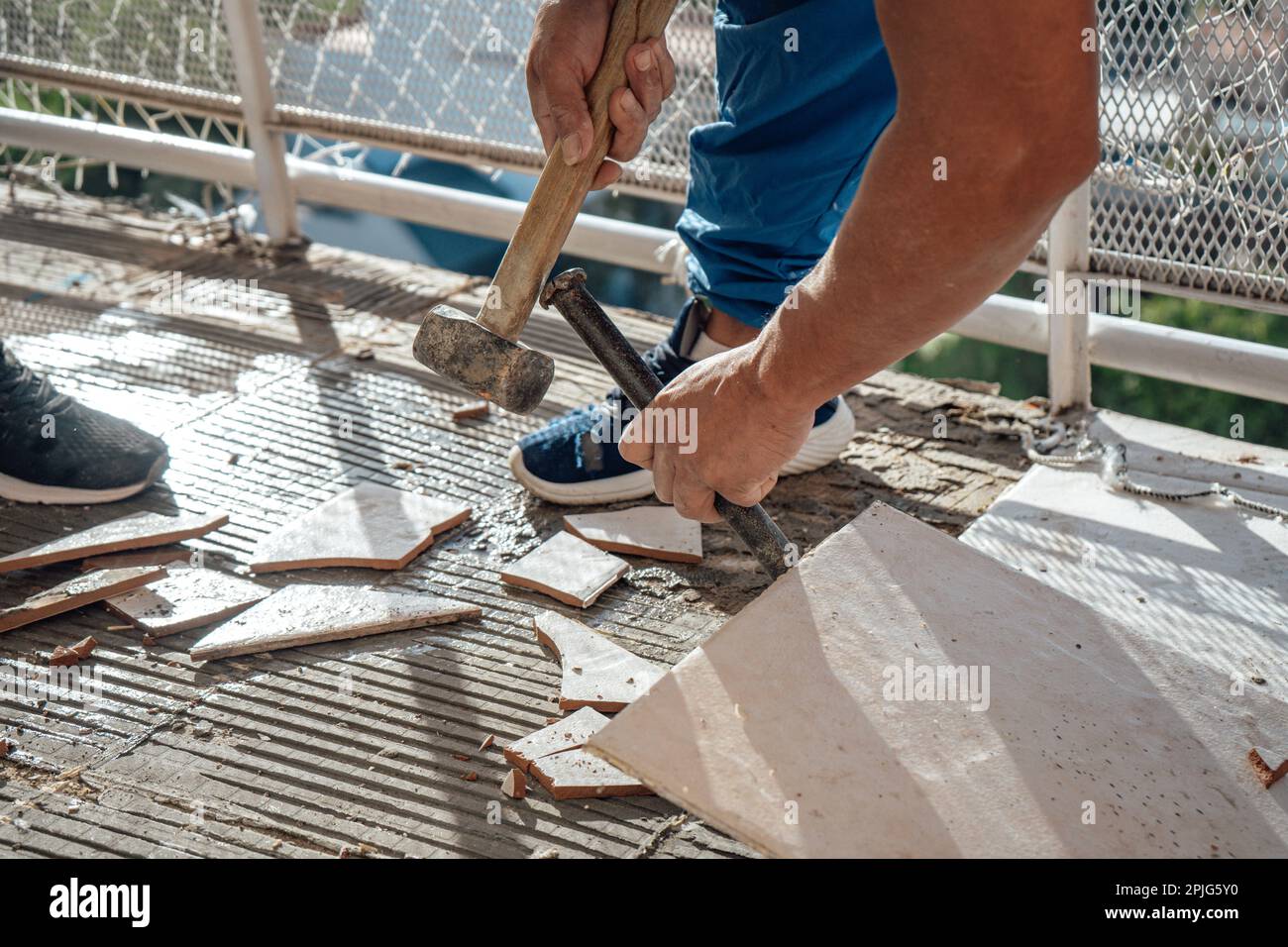 Bricklayer breaking some floor tiles. Working in a construction ...