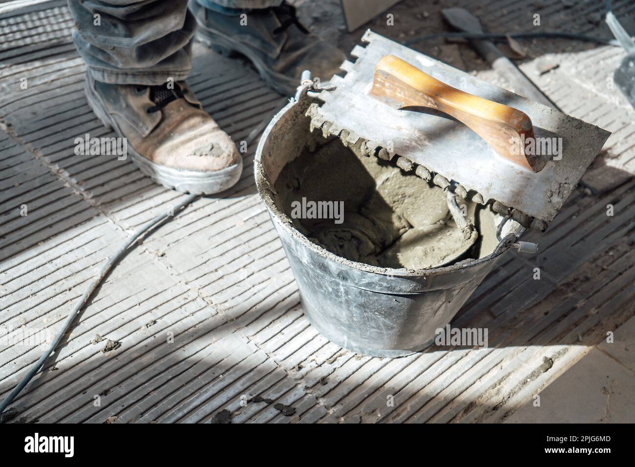 Mason's bucket with cement and a trowel in a construction site. Work in ...