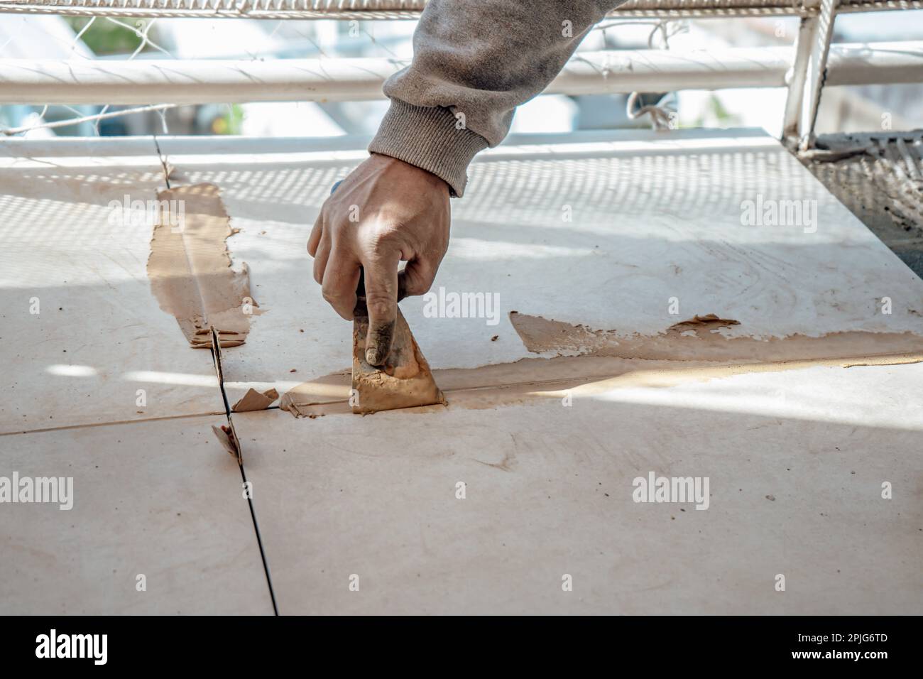 Mason passing the paste in the joint between tiles. I work in a ...
