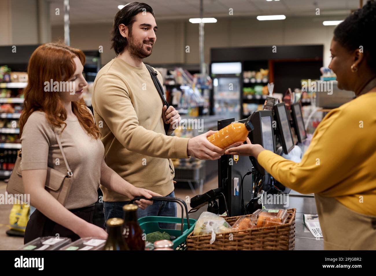 Side view portrait of young couple standing by cashiers desk in ...