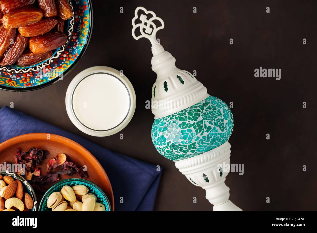 Ramadan Kareem food and drinks. Date fruits, nuts and milk on a dark ...