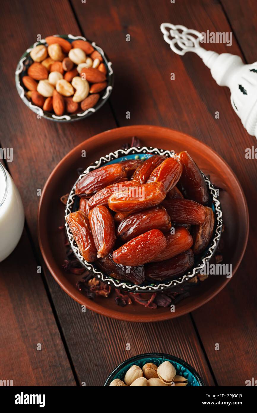 Ramadan Kareem and iftar muslim food. Pitted dates, nuts and milk on ...