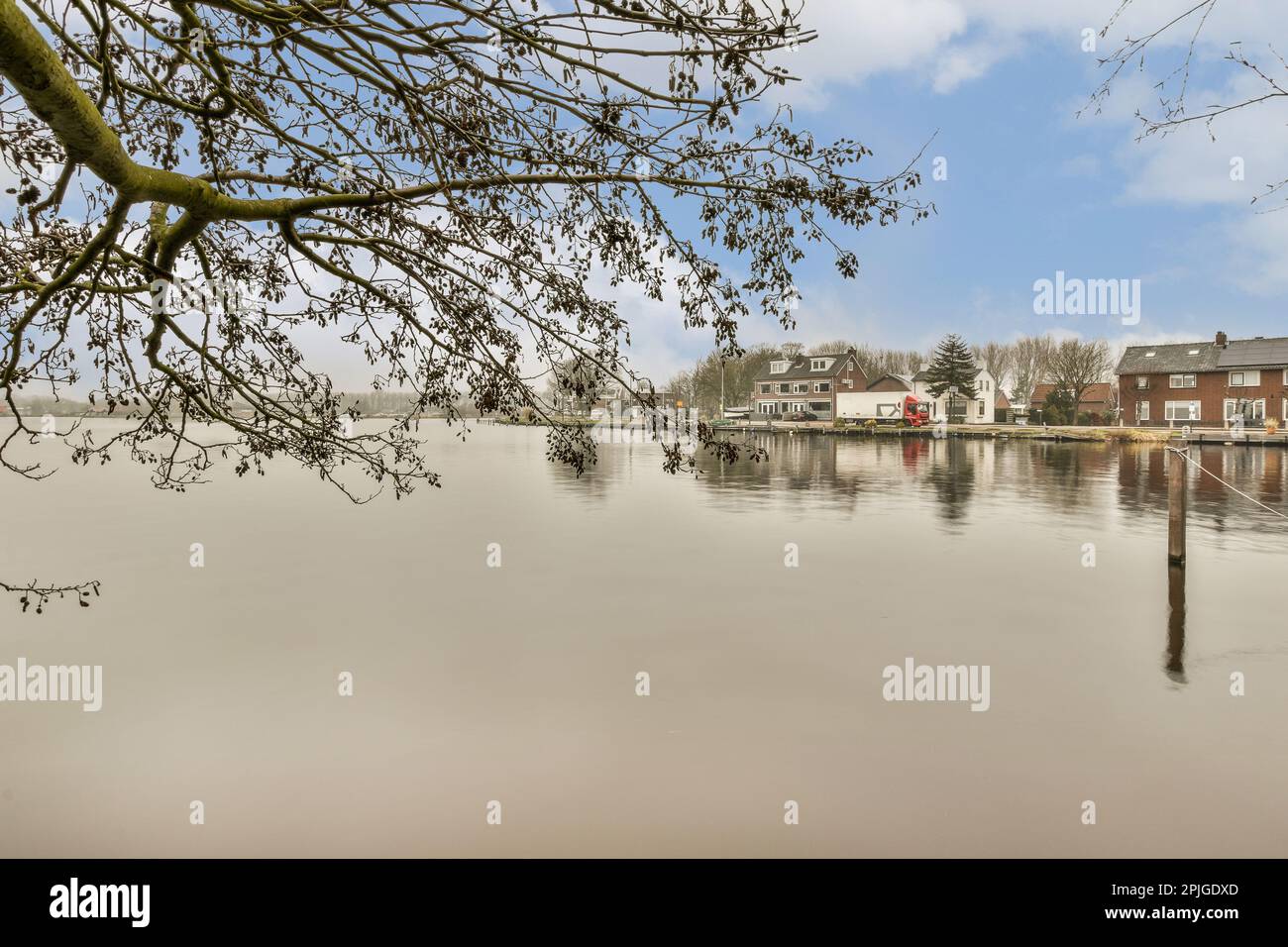 a flooded area with houses in the distance and trees on the other side ...