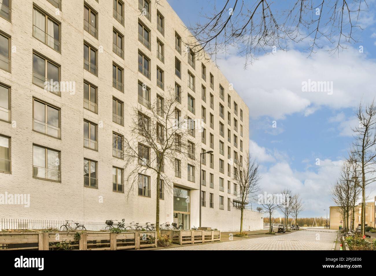an empty street in front of a large white brick building with many ...