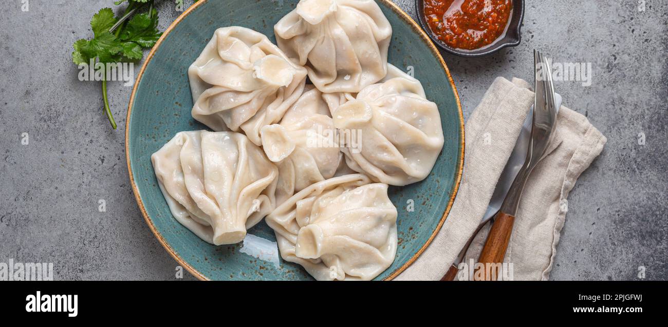 Georgian dumplings Khinkali on plate with red tomato sauce and fresh ...