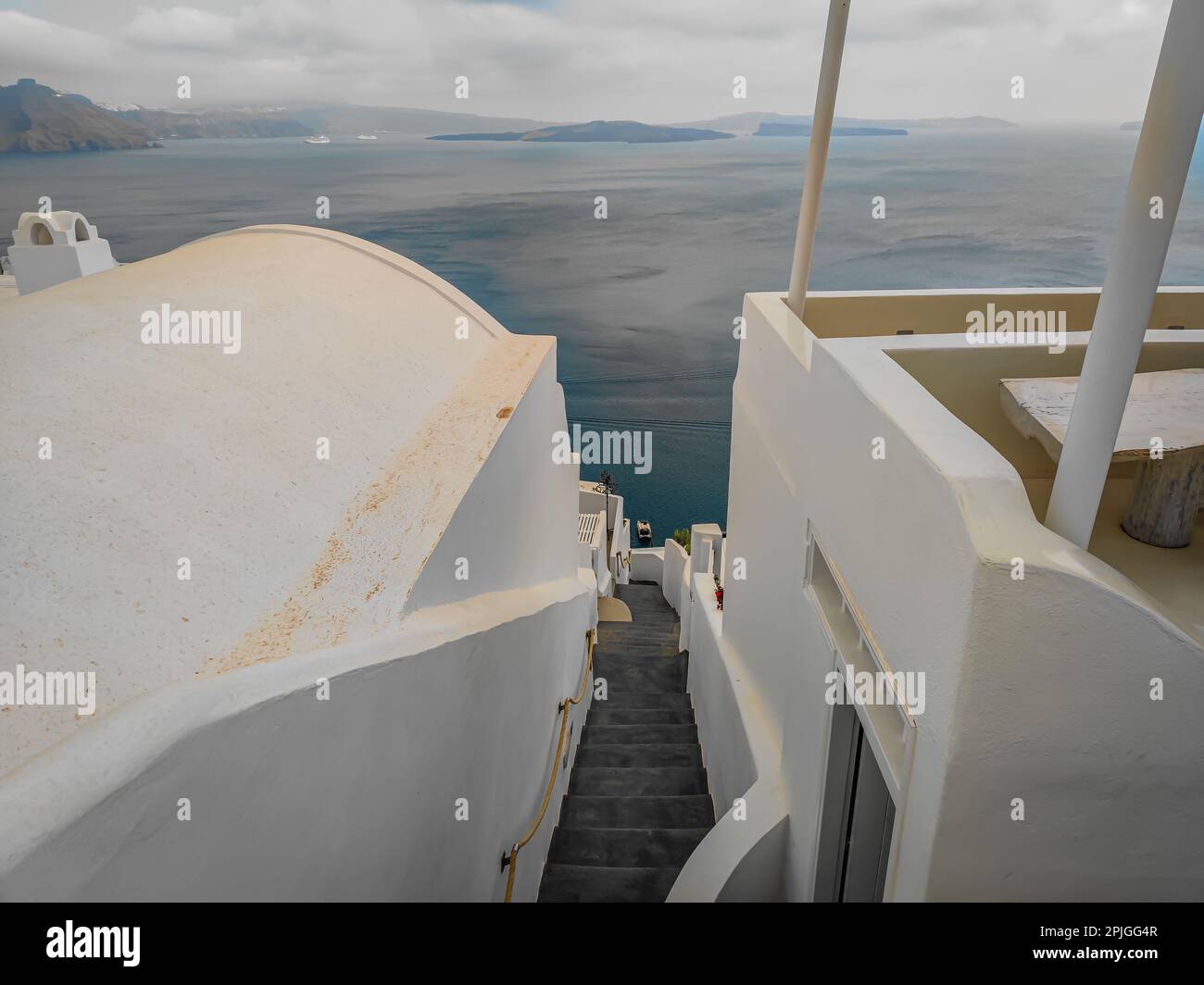 White narrow stairs between white Santorini houses heading to the top ...