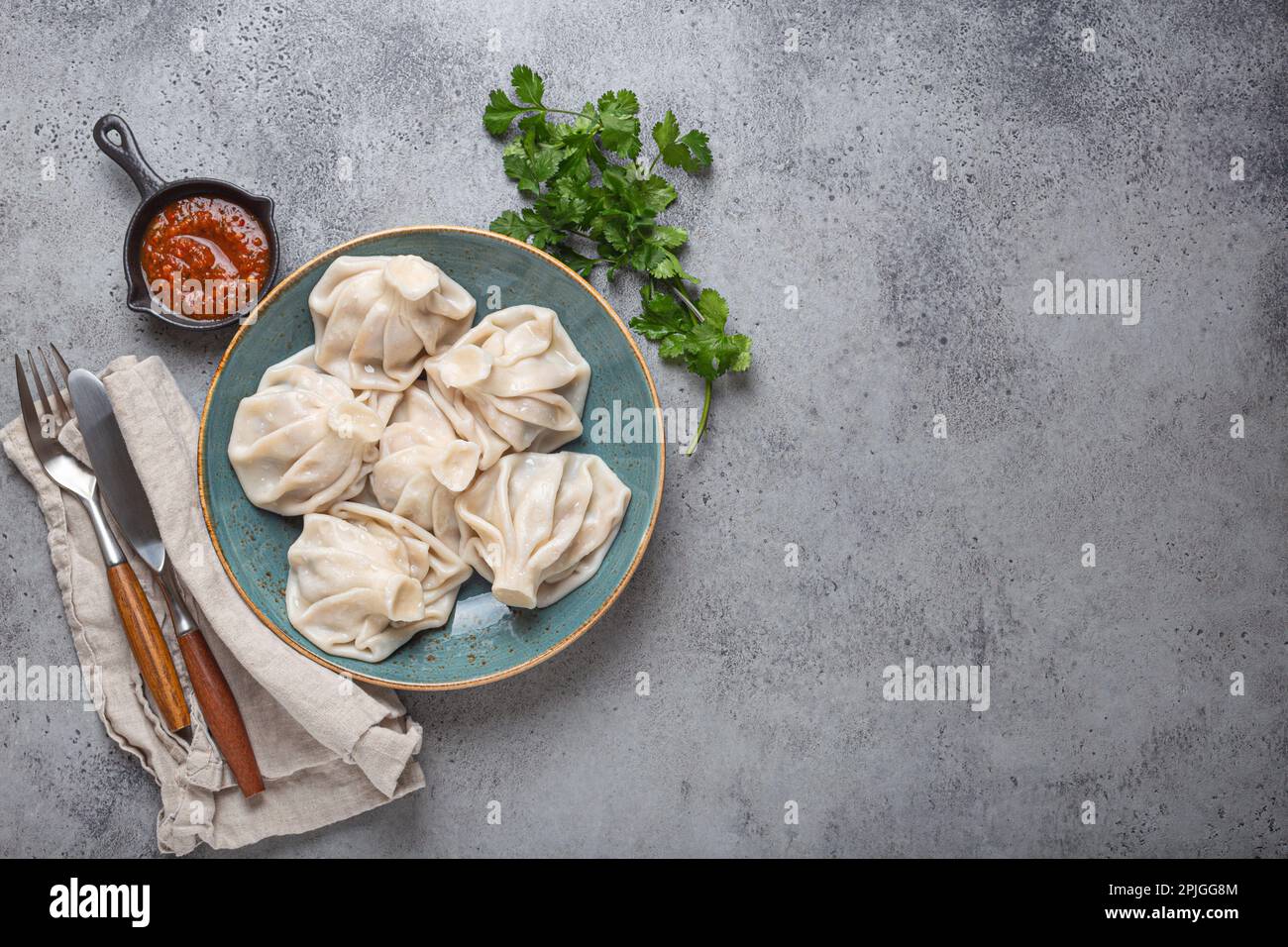 Georgian dumplings Khinkali on plate with red tomato sauce and fresh ...