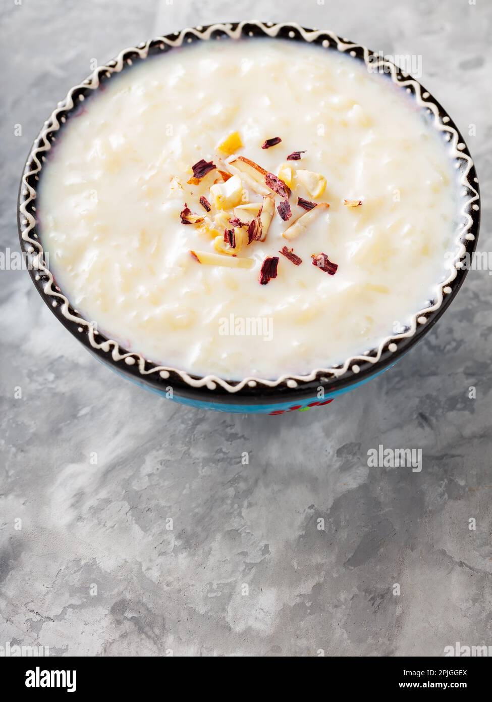 Bowl with rice pudding on a gray background. Rice kheer with cashew ...