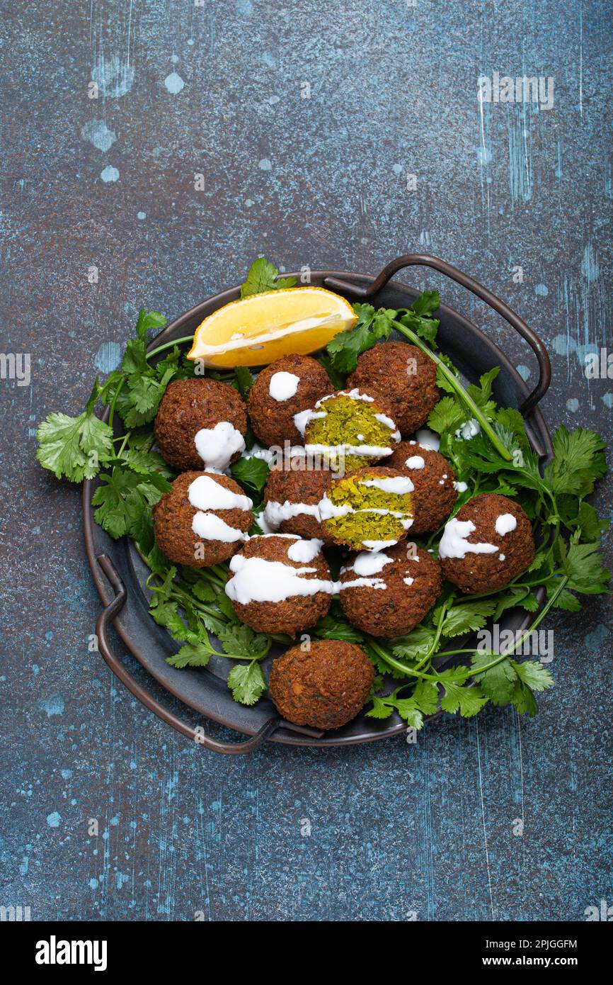 Plate of fried falafel balls served with fresh green cilantro and lemon ...