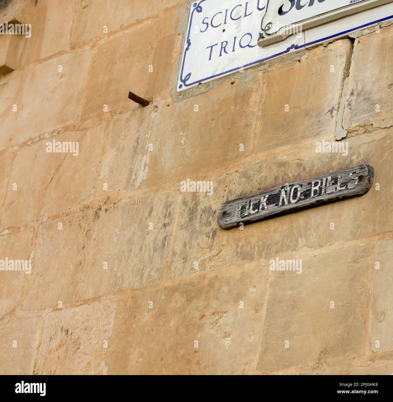 Weather worn Stick no bills sign on a sandstone wall in Malta Stock ...