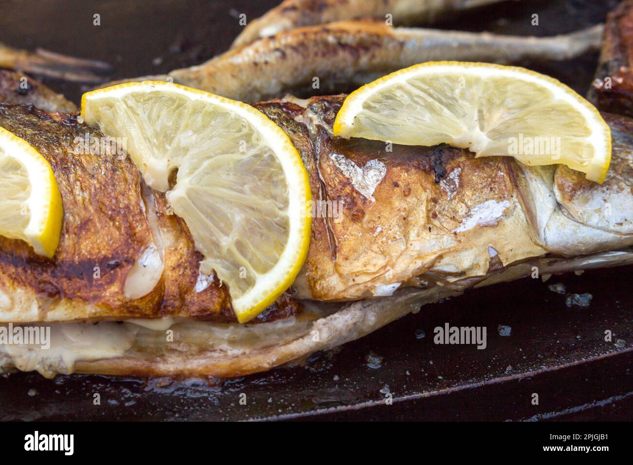 grilled spicy fish closeup. Cooking, the process. Fried fish for lunch ...