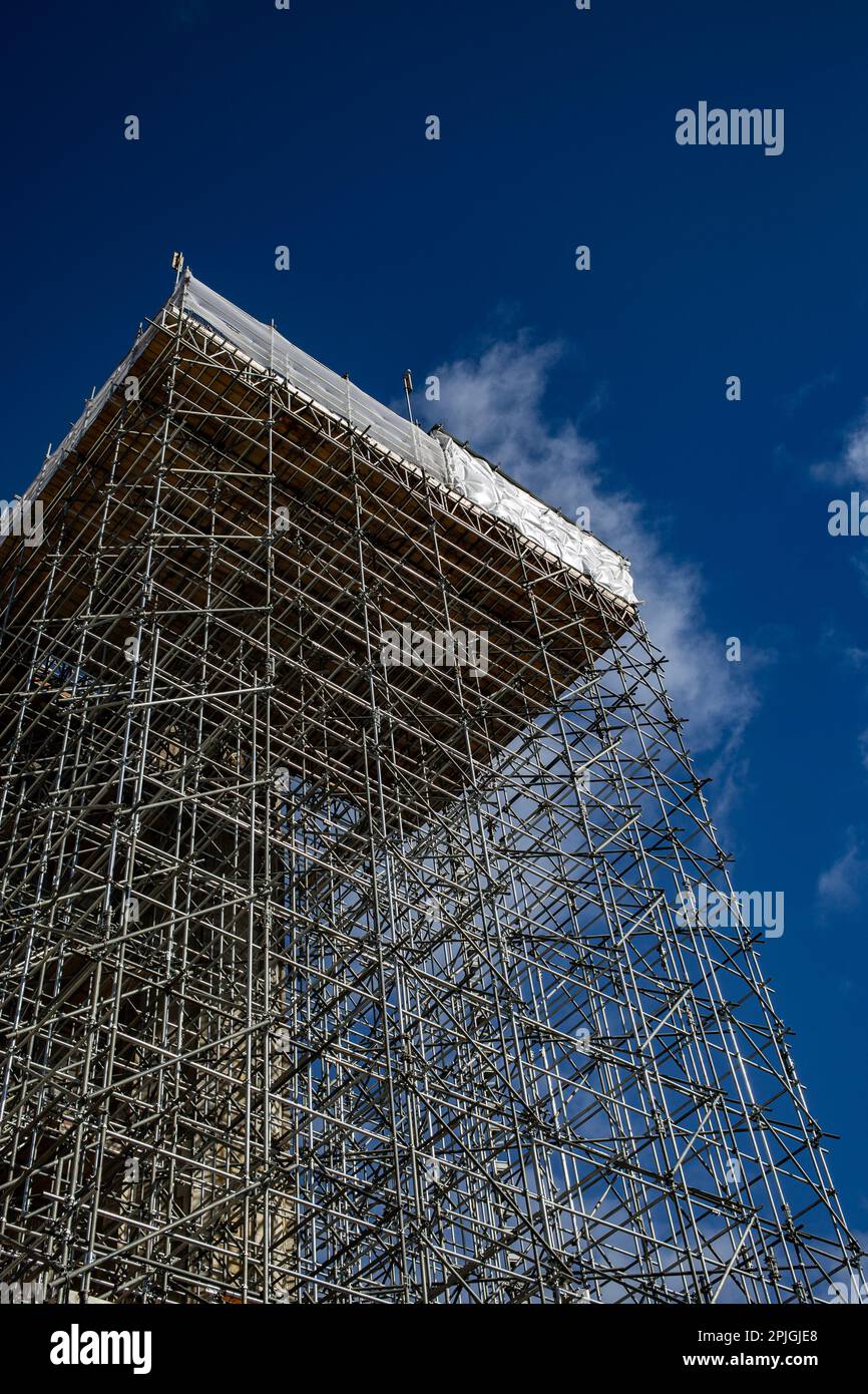 Scaffolding around a tall building against a blue sky Stock Photo - Alamy