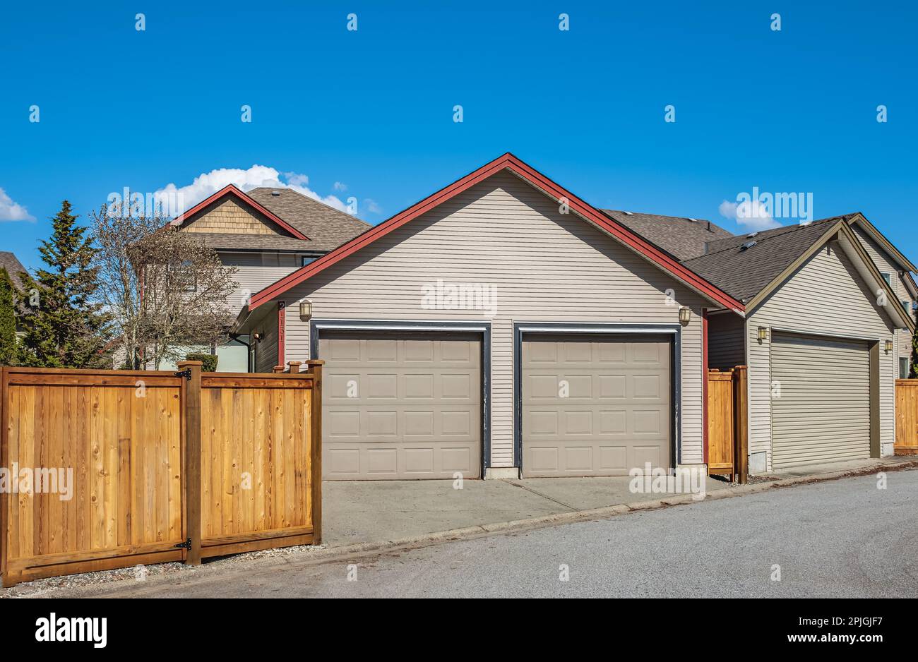 Double garage with short driveway in a sunny day. Wide Garage Door with ...