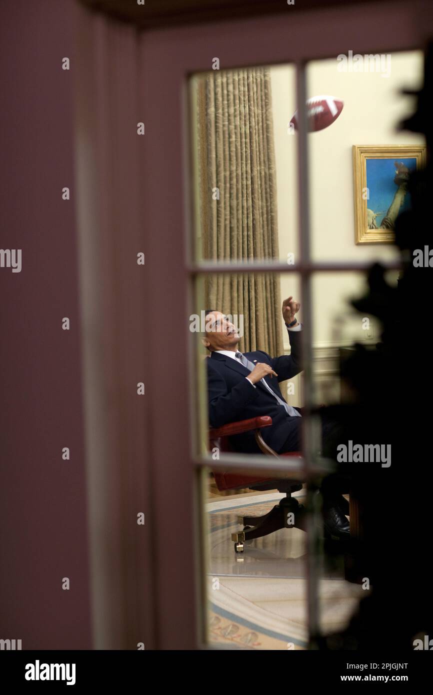 President Barack Obama plays with a football in the Oval Office 4/23/09 ...
