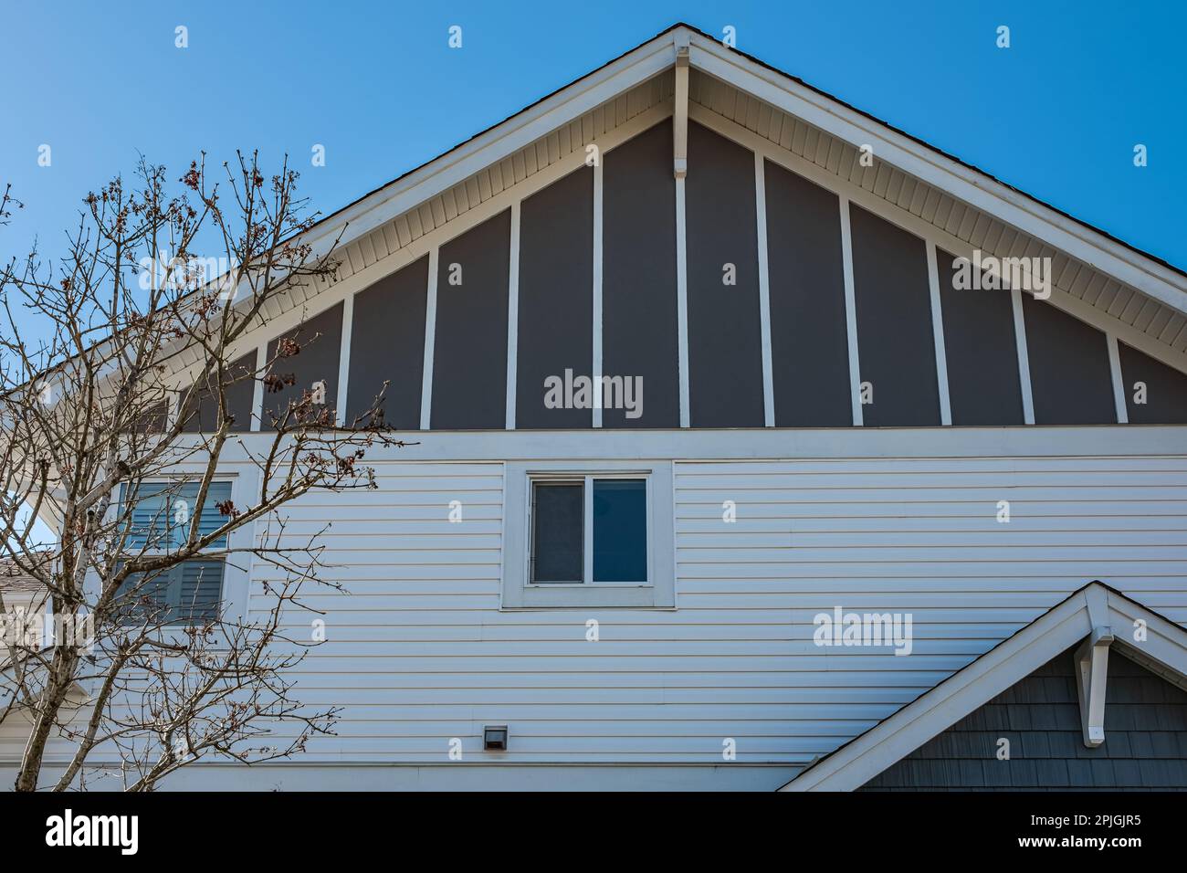 Top of a house with nice windows in the blue sky background. Beautiful ...