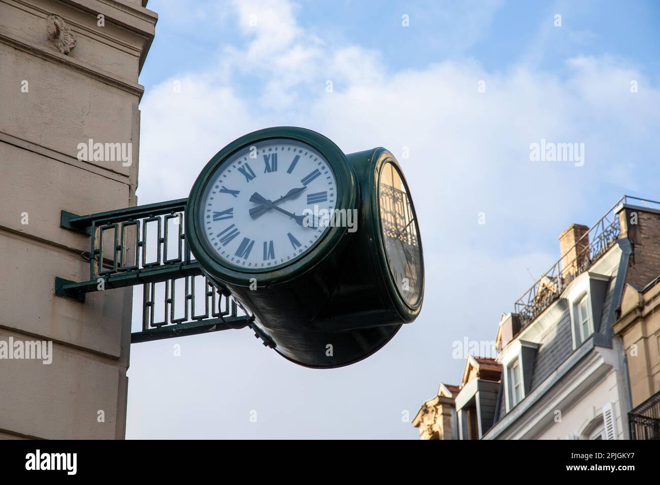 View of an old green analog clock on a street corner in Strasbourg in ...