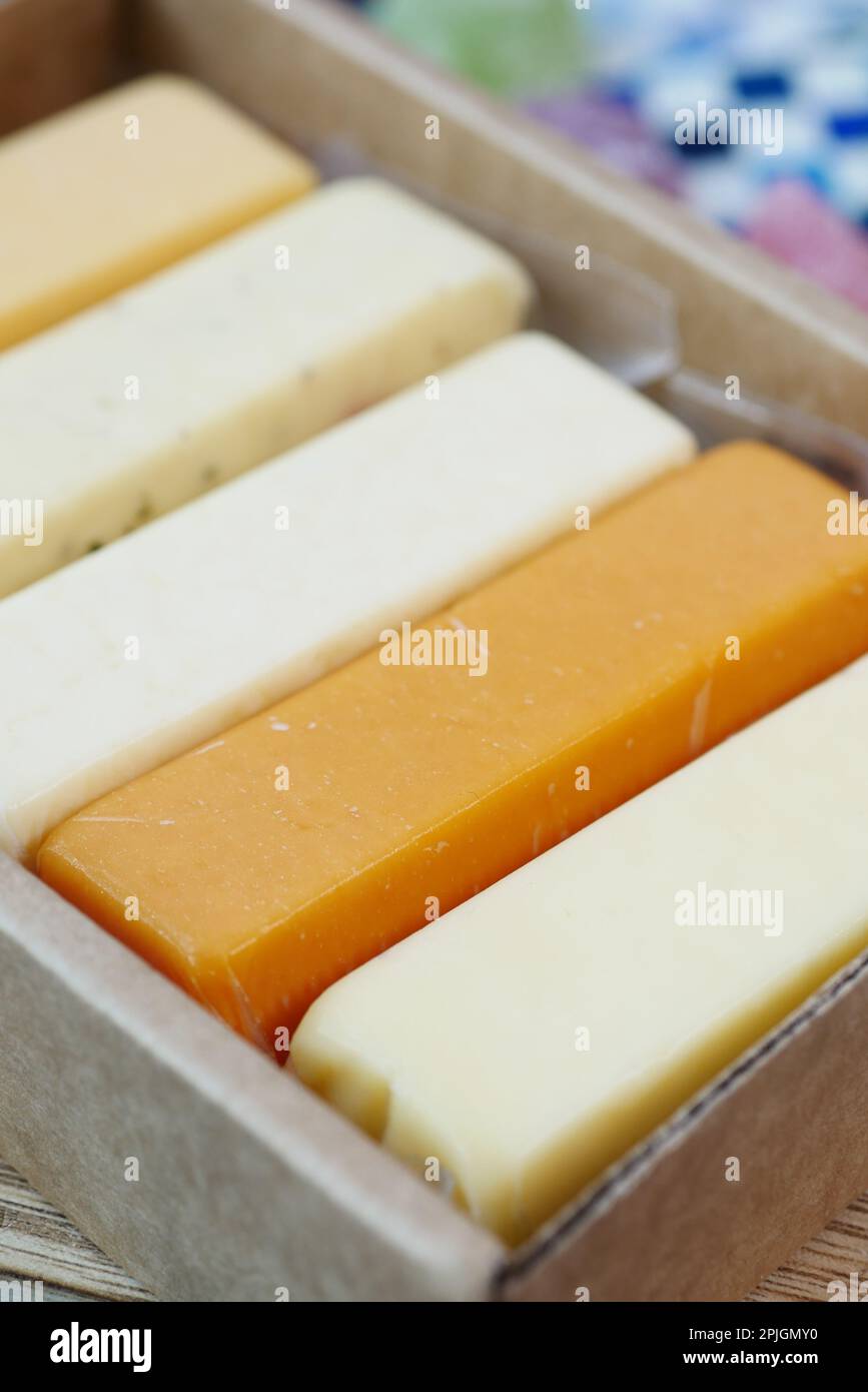 Cheese cubes green, yellow and red color on chopping board Stock Photo ...