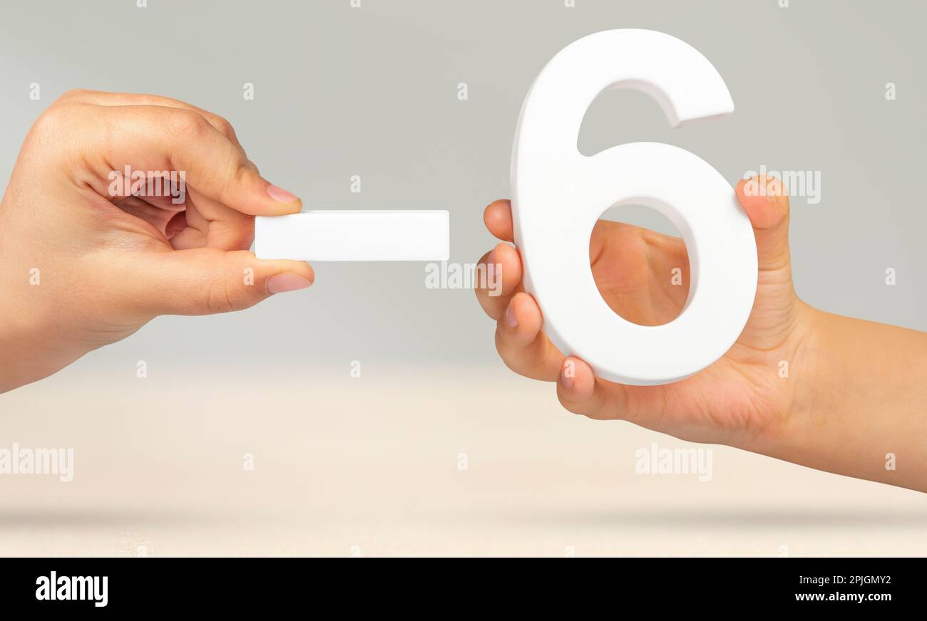 Minus six. The number six and the minus symbol in a hand close-up on a ...