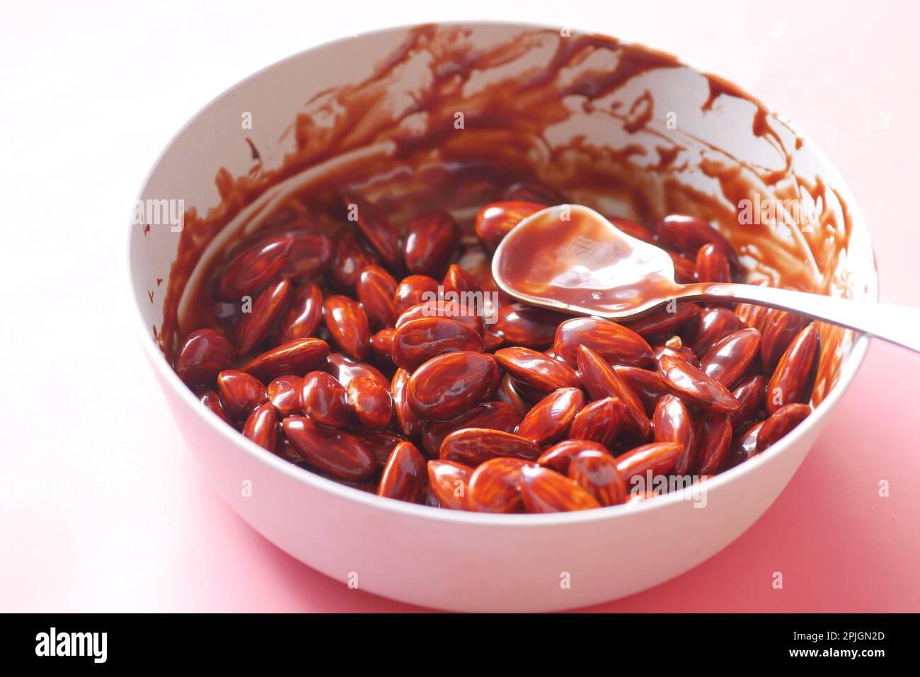 dark chocolate cream pouring on almond nut on white Stock Photo - Alamy