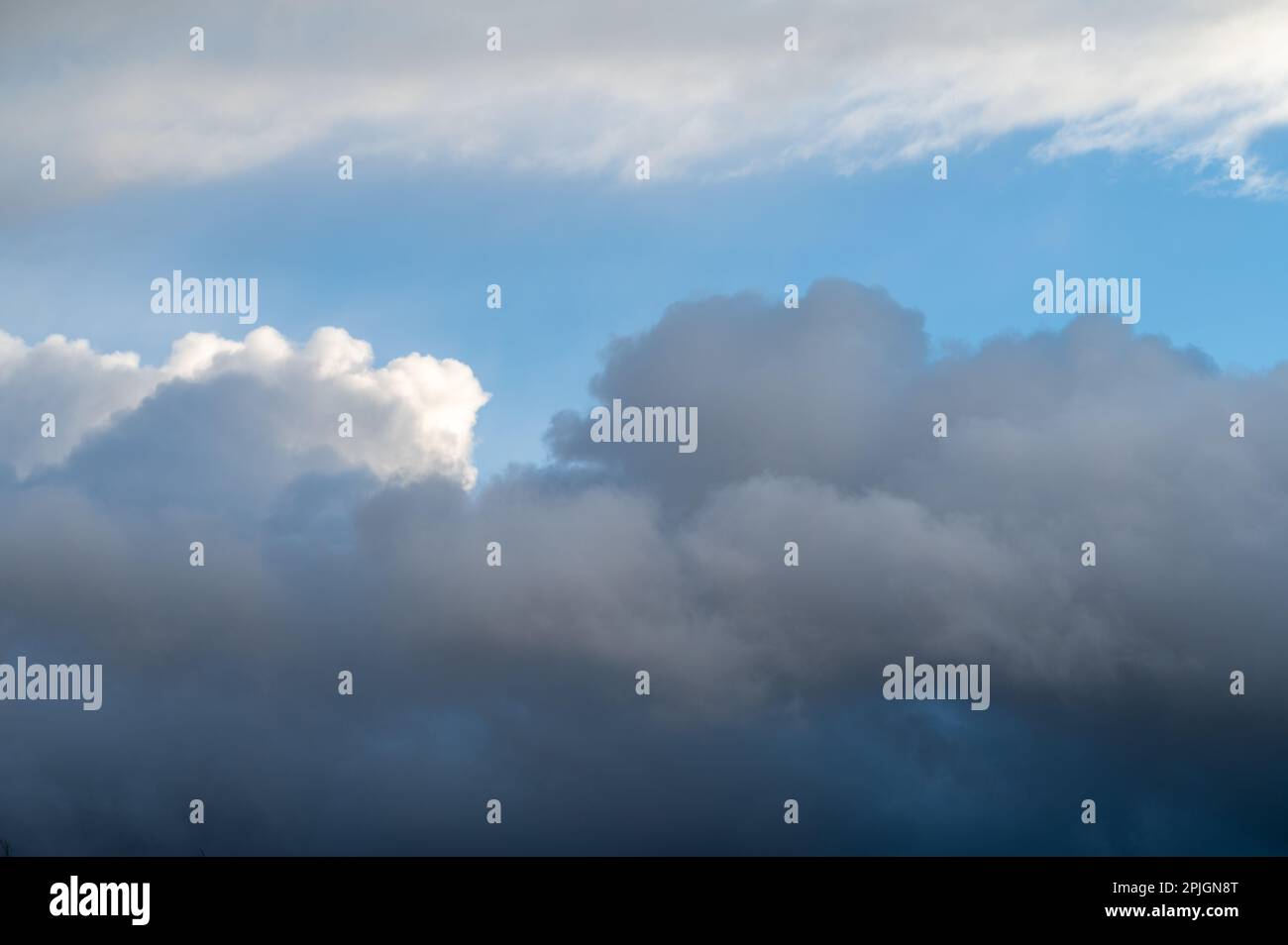Dark and white clouds against a blue sunny sky Stock Photo - Alamy