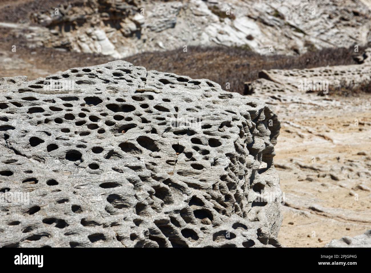 A huge rock eroded by the sea lies on the shore of Ios Island, Greece ...