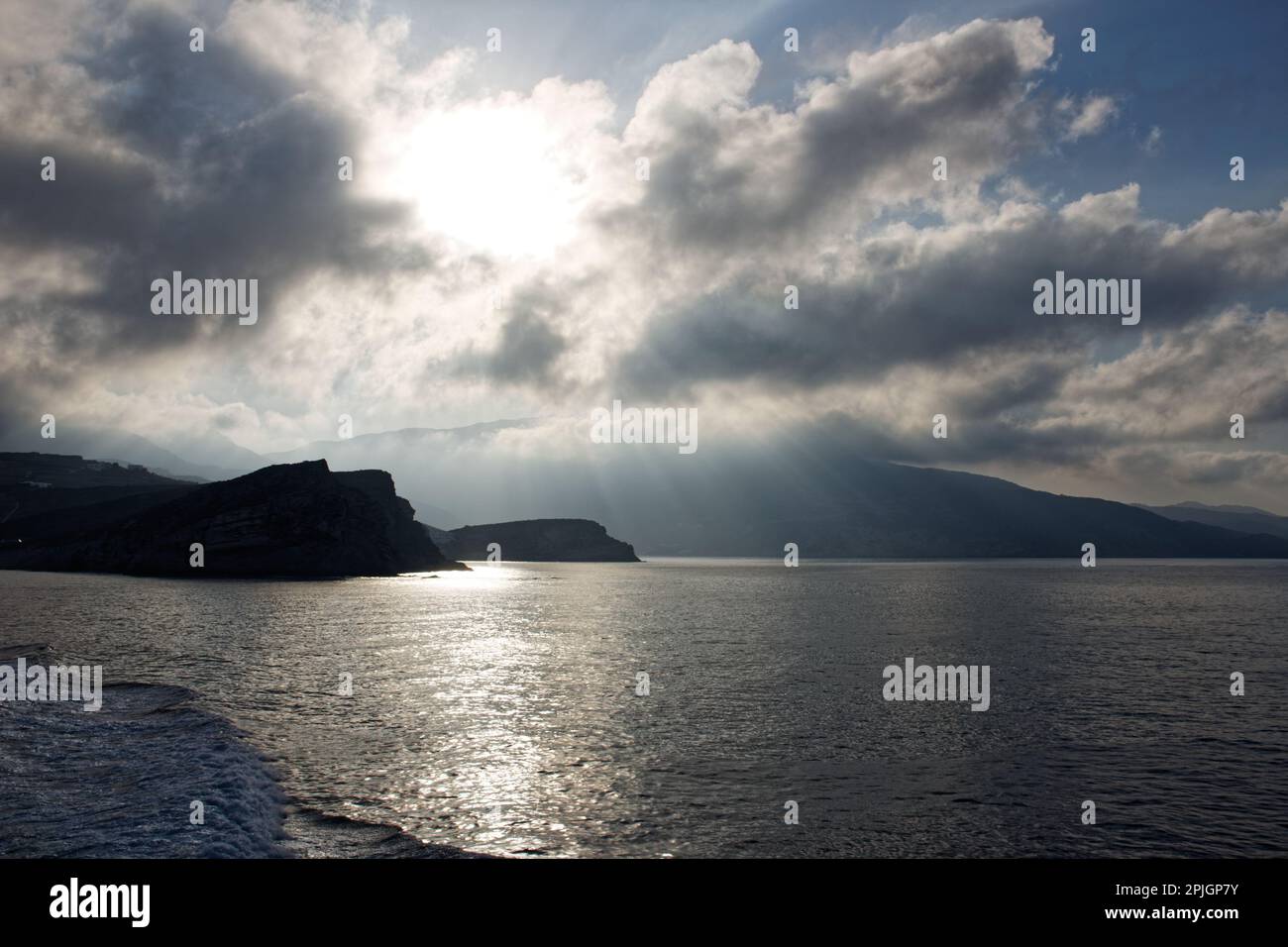 The rising sun shines through the morning clouds as the ferry leaves ...