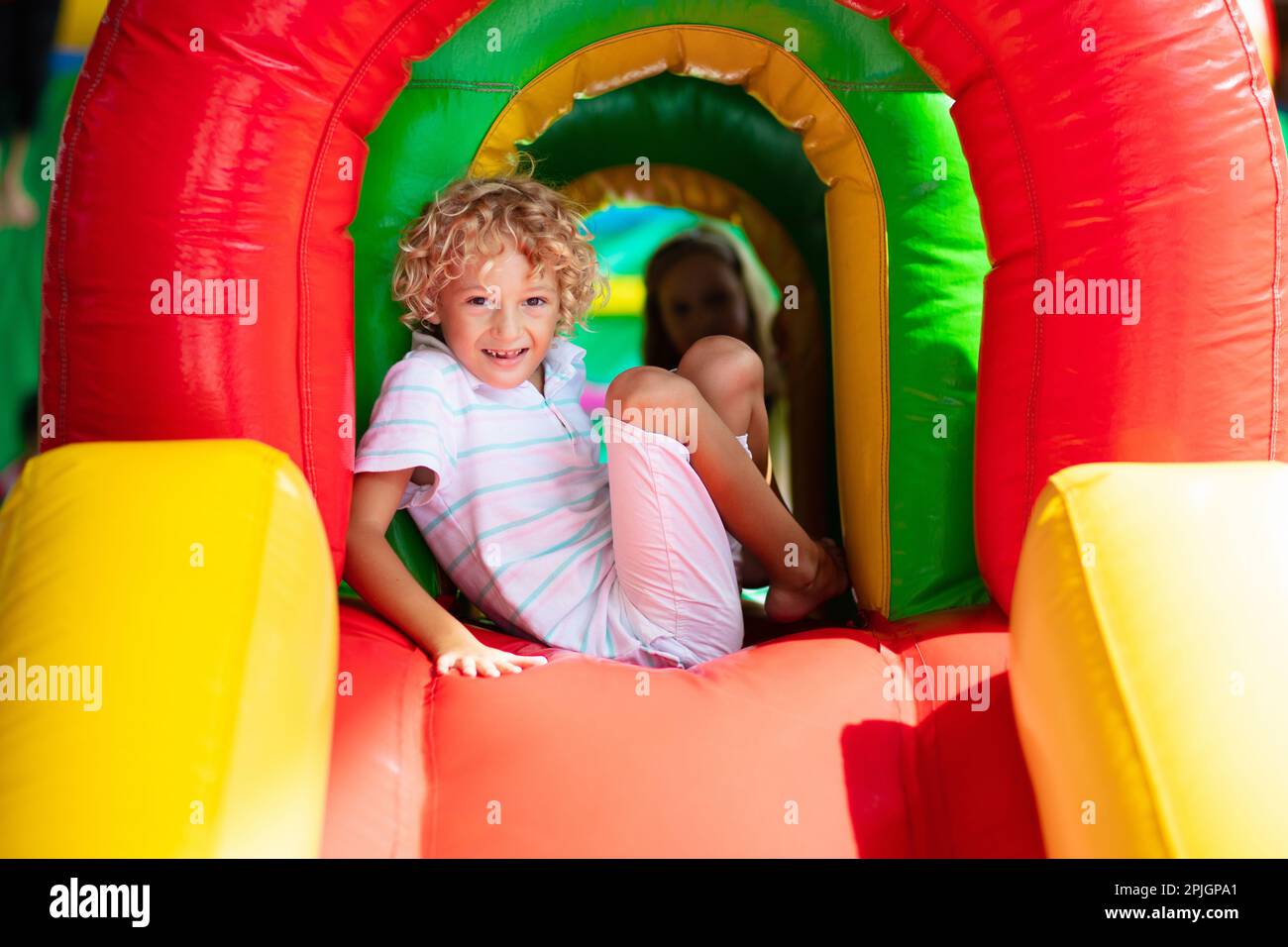 Child jumping on colorful playground trampoline. Kids jump in ...