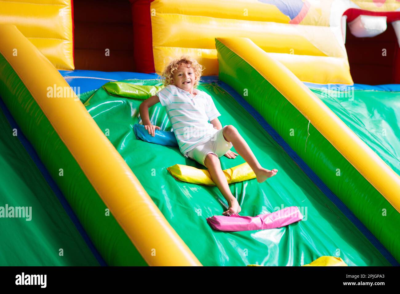 Child jumping on colorful playground trampoline. Kids jump in ...