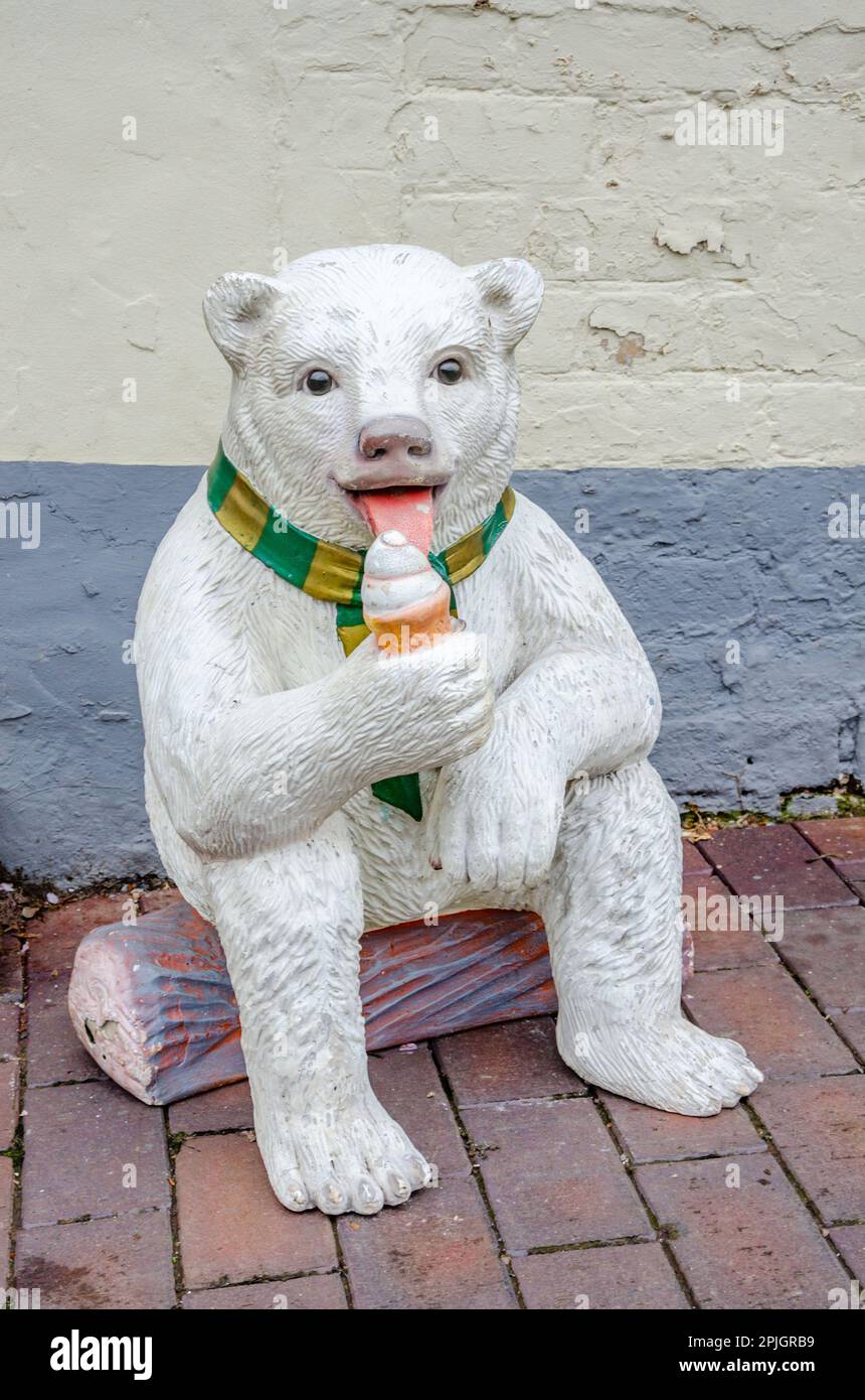 A model of a white bear sat on a log eating an ice cream on the ...
